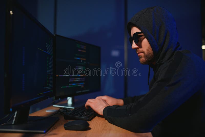 Hacker Sitting At Desk In Dark Atmosphere A Computer Programmer Or Hacker Anonymous Computer