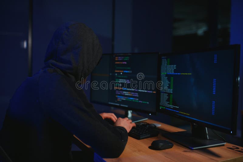 Hacker Sitting At Desk In Dark Atmosphere A Computer Programmer Or Hacker Anonymous Computer