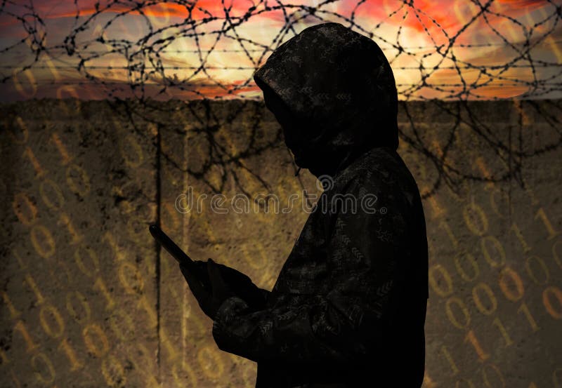 A Hacker Stands Against the Wall of a Prison with Barbed Wire ...