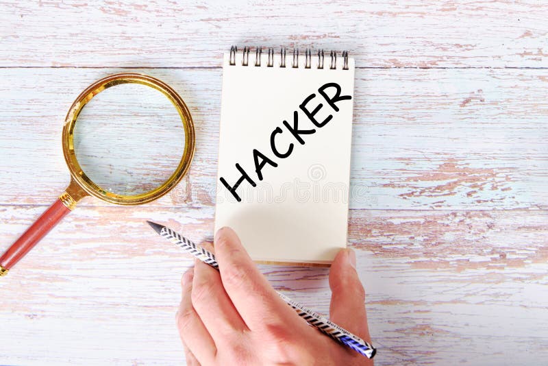 Hacker Word on a Notebook in a Man S Hand with a Pencil and a ...