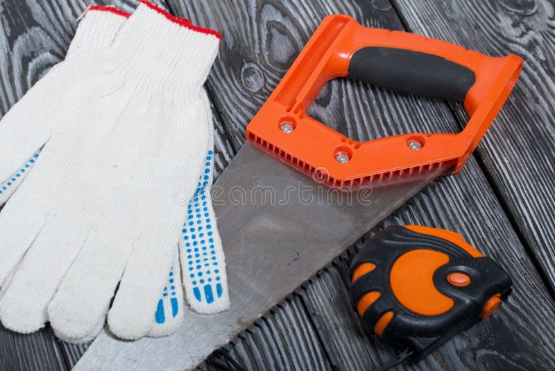 A Hacksaw, Work Gloves, and Measuring Tape Lie on Painted Pine Boards ...