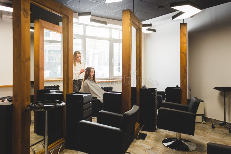Hairdresser Combs The Girl S Hair By Styling In A Beauty Salon Stock