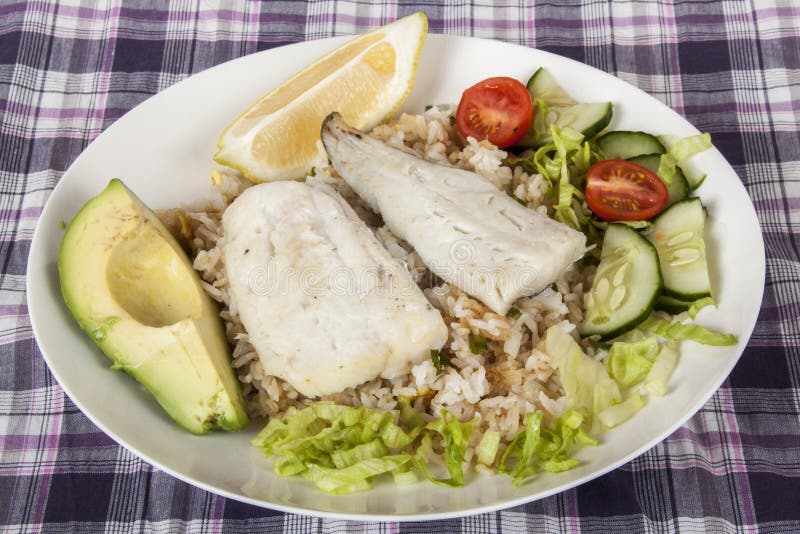 Hake on Fried Jasmine Rice with Lemon, Avocado and Salad Stock Image ...