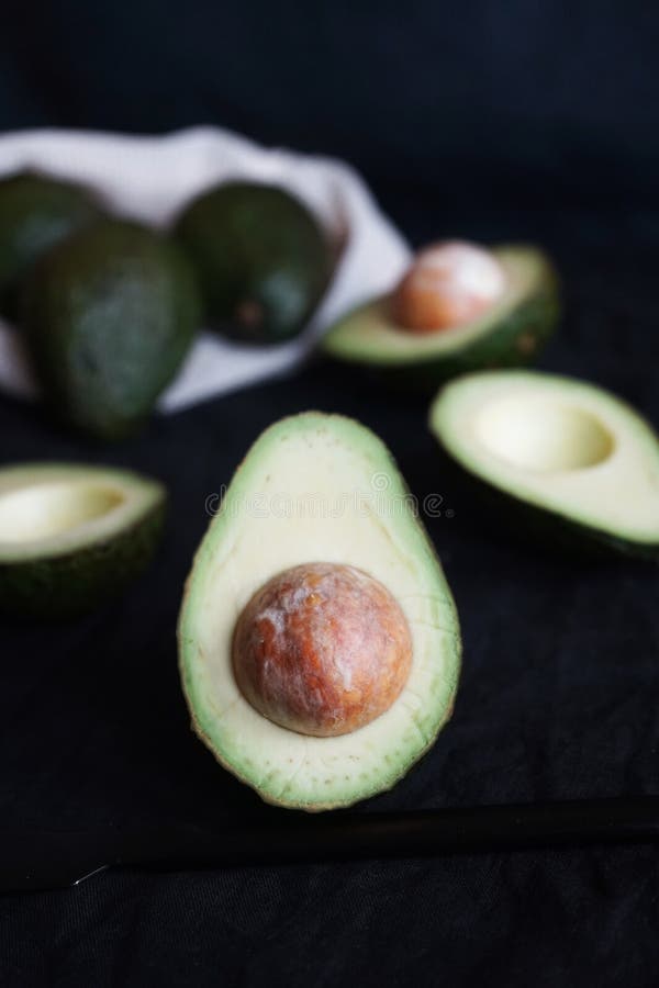 Cut and Whole Ripe Avocados on a Dark Background Stock Image - Image of ...