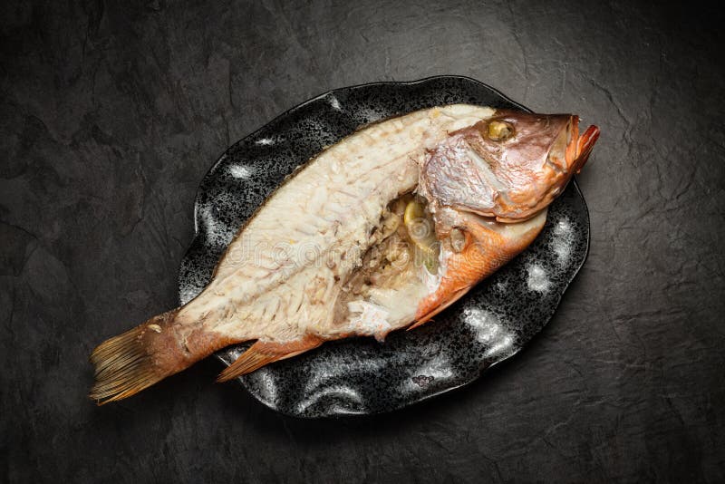 Half Eating Red Snapper with Exposed Bones, on Dark Background Stock ...