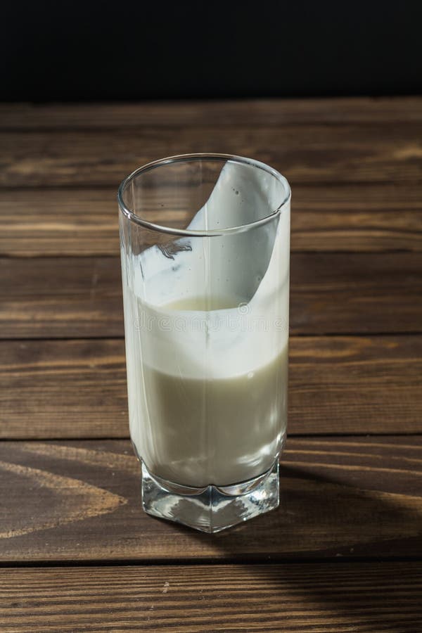 A Half Full Glass of Milk is on the Table Stock Image - Image of table ...