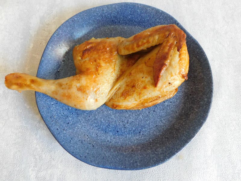 Half of the Grilled Chicken is on a Blue Plate on the Table Stock Photo ...