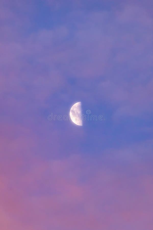 Half Moon Illuminated in the Sky Surrounded by Colorful Clouds from a ...