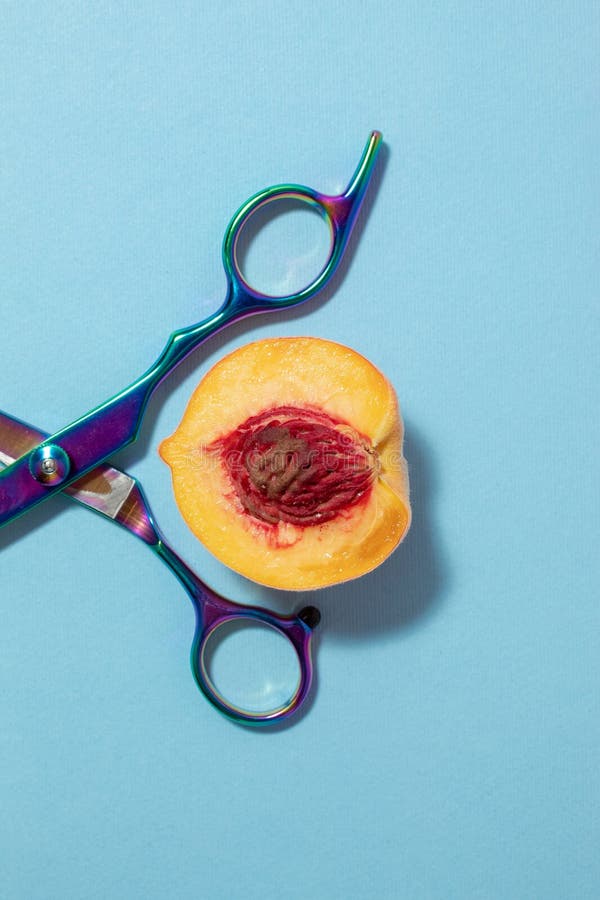 Half of a Peach Placed between the Handles of Scissors on a Blue ...