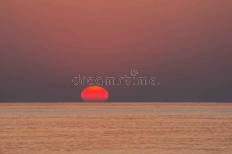 Half Red Sun at the Horizon from the Sea while Sunrise Stock Image ...