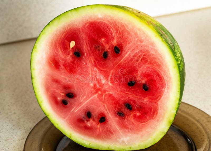 Half of Sliced Watermelon on Brown Plate on Table Stock Image - Image ...