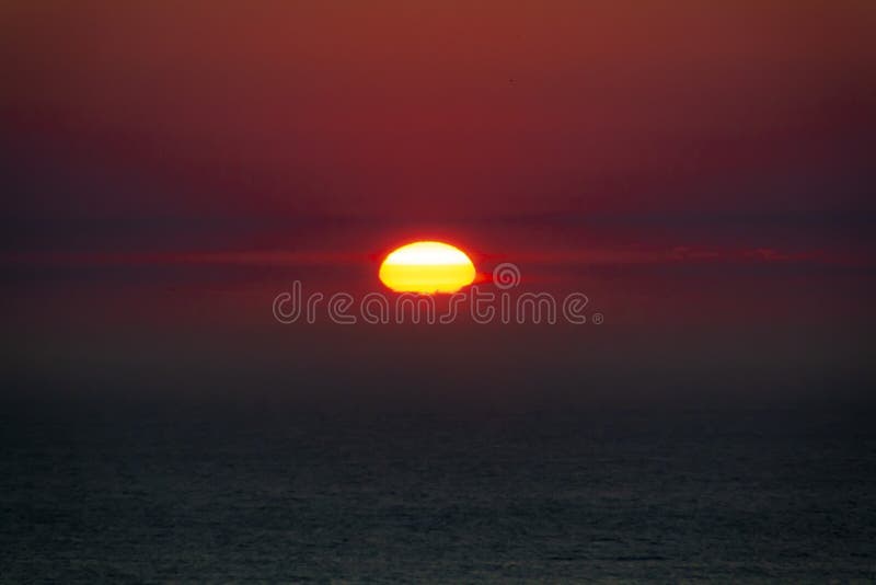 Half of Sun Was in Horizon at the Grey Colour Sea in the Twilight. the ...