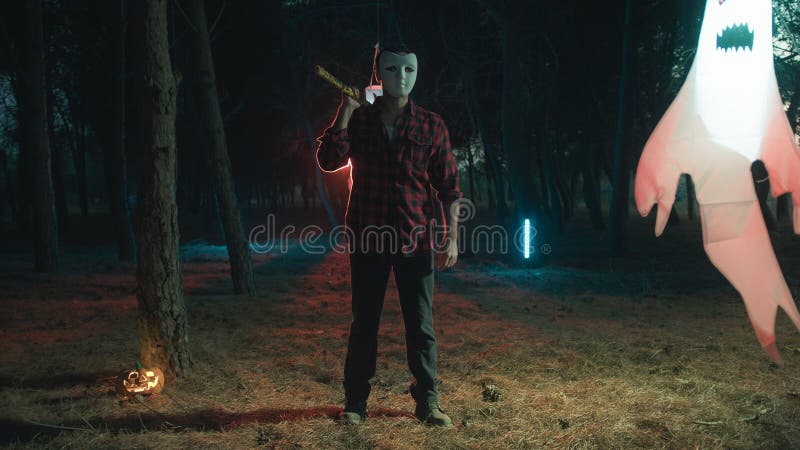 Silhouette of a Man Armed with an Axe Behind the Silhouette of a Ghost ...