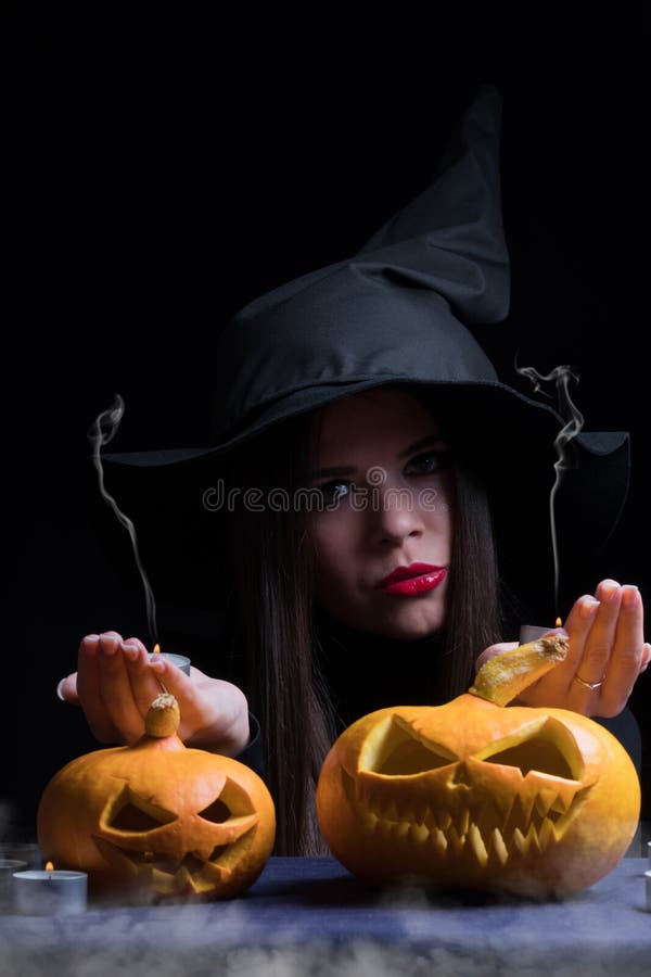 Halloween Witch With A Magic Pumpkin Beautiful Young Woman In Witches Hat And Costume Holding