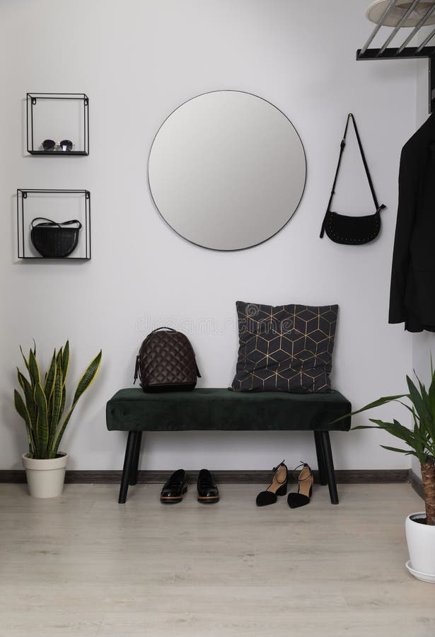 Hallway with Black Bench, Shoes and Round Mirror on Light Wall Stock ...
