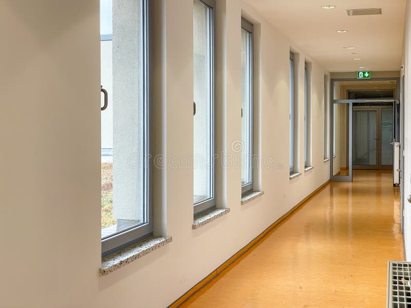 A Hallway with a Row of Windows and a Door Stock Photo - Image of ...