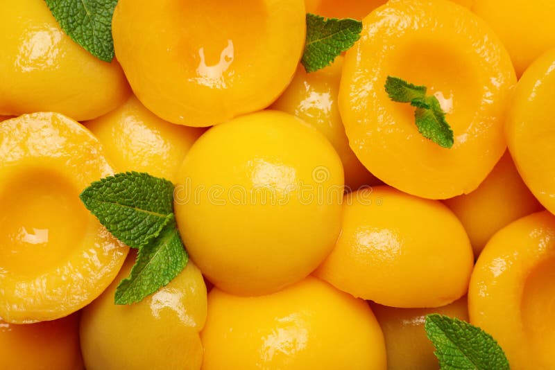 Halves of Canned Peaches with Mint Leaves As Background, Top View Stock ...