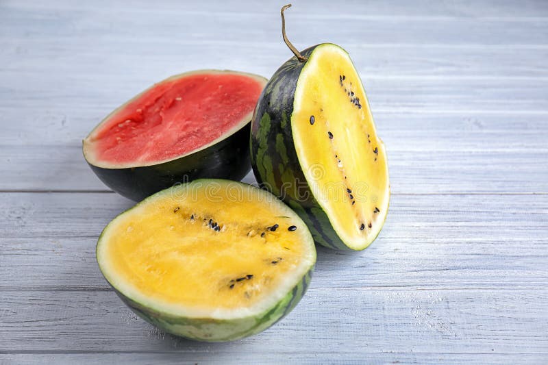 Halves of Yellow and Red Watermelons on White Wooden Table Stock Photo ...