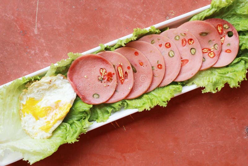 Ham Cut into Circular Discs with Red Peppers and Egg Fried. Stock Image ...
