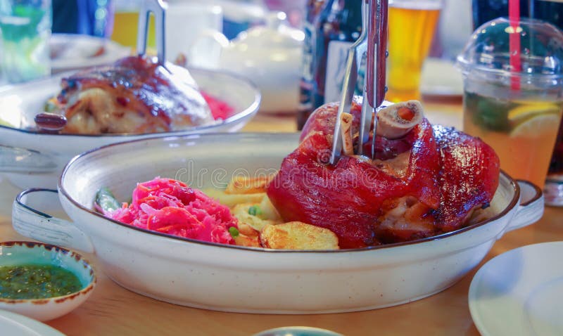 A Ham Hock or Hough or Pork Knuckle with Cabbage, Potatoes and Pickles ...