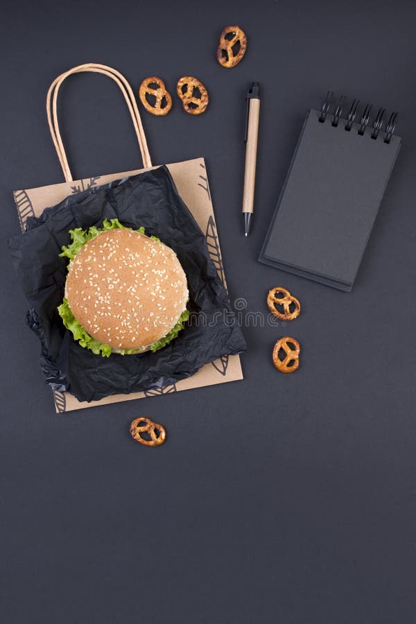 Hamburger on a Black Background for Lunch. Notepad for Text and ...