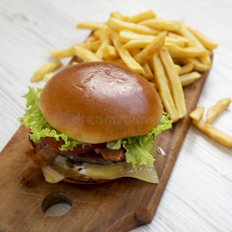 Hamburger with Lettuce, Cheese and Bacon on a Rustic Wooden Board on a ...