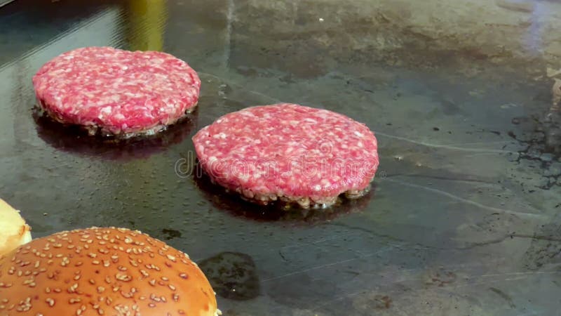 Hamburger Patties Fried on a Flat Griddle and Burger Buns on the Side ...