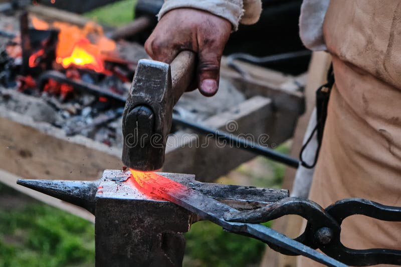 Hammer Blow on Hot Workpiece is in the Grip of Blacksmith. Brazier, Red ...