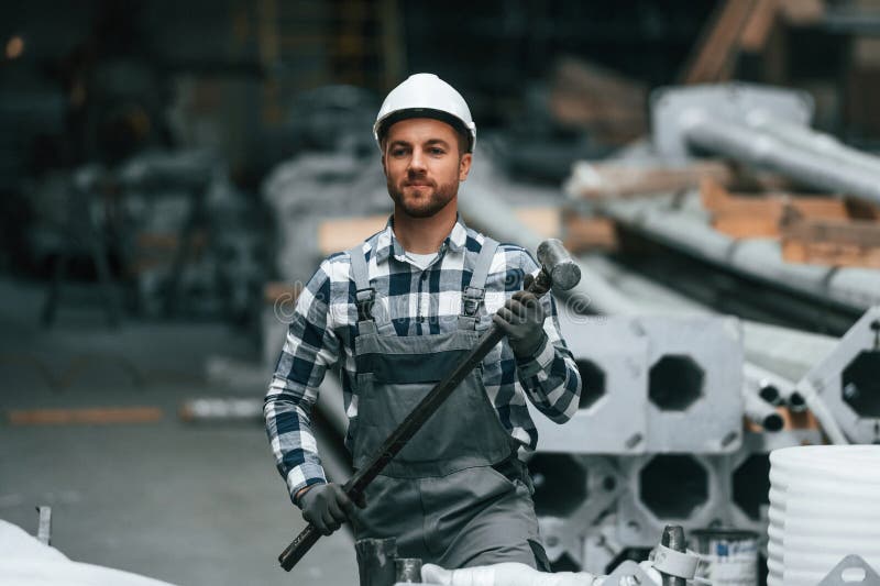 With Hammer. Factory Male Worker in Uniform is Indoors Stock Image ...