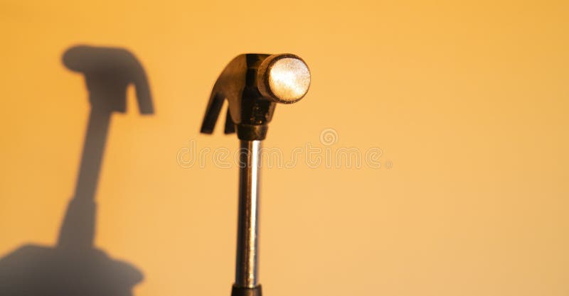 Hammer and Its Shadow Cast on the Warm-toned Wall. Stock Image - Image ...