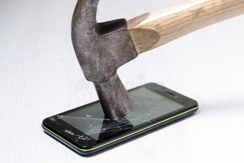 The Hammer Smashes the Smartphone Screen Lying on the Table Stock Image ...