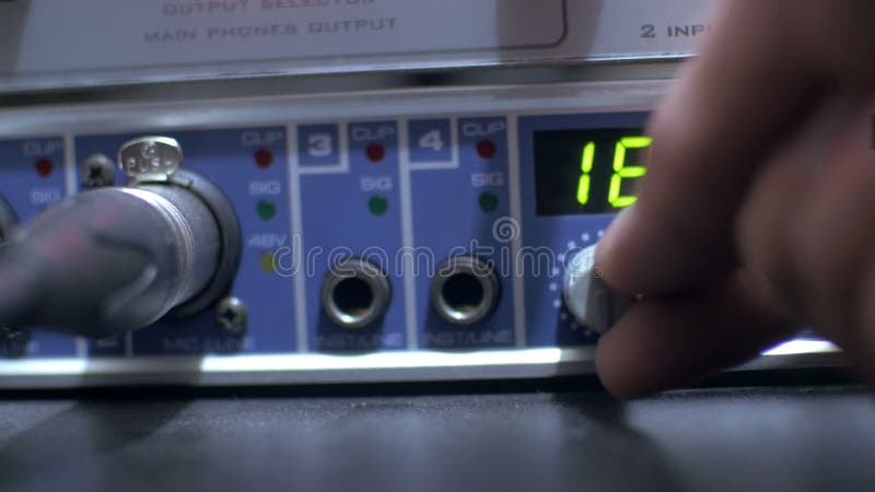 Hand Adjusting the Buttons on a Functioning Audio Amplifier in a Sound ...