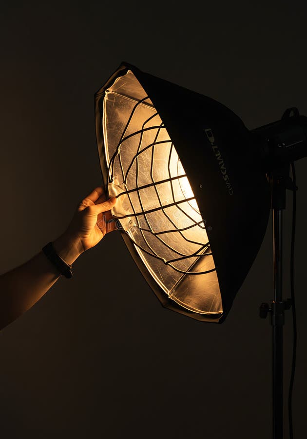 Hand Adjusting Studio Light: Dramatic Warm Glow, Dark Background Stock ...