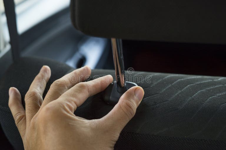 Hand Adjusts Headrest in Car Interior. Adjusting the Seat Position in ...