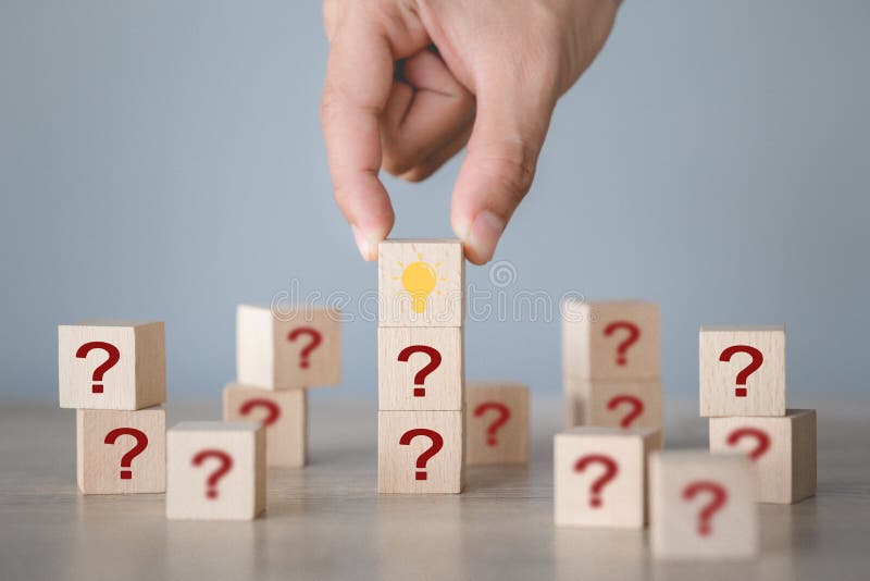 Hand Arranging Wood Block Stacking with Icon Question Mark and Lamp ...