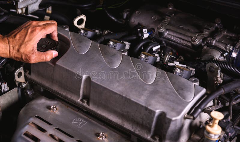Hand of Auto Mechanic Technician Service Engine and Open the Engine Oil ...