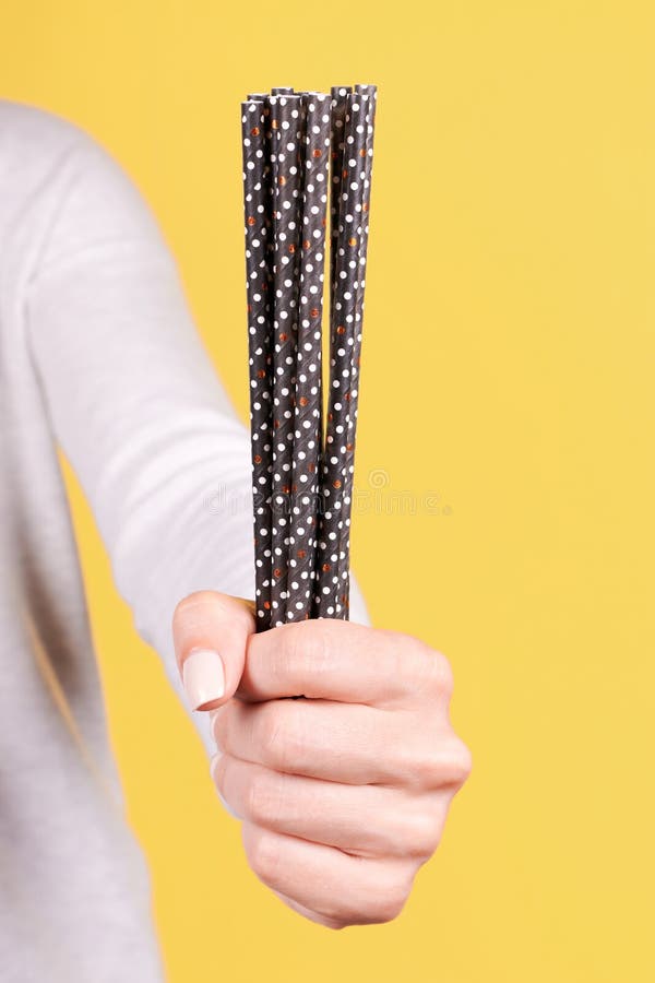 Hand with Black Drinking Straw. Isolated on Yellow Background Stock ...