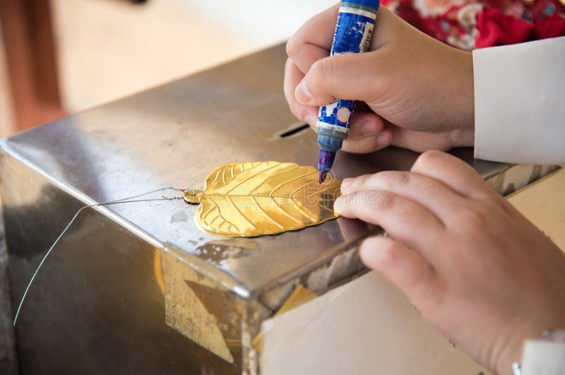 A Hand with Blue Pen for Writing Name on Gold Leaf Stock Photo - Image ...