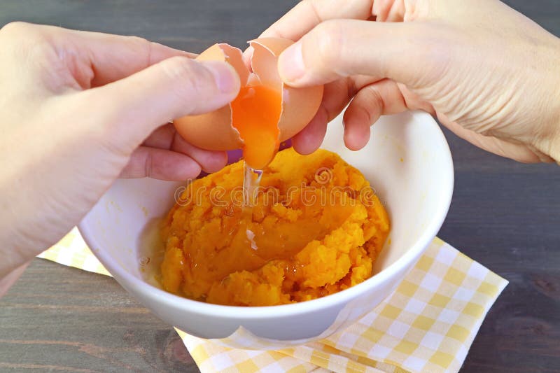 Hand Breaking an Egg on Pumpkin Puree Bowl for Pumpkin Pie Filling ...
