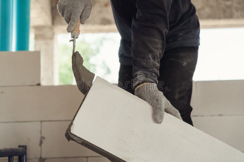 Hand of Bricklayer with Trowel To Installing Lightweight Brick in a New ...