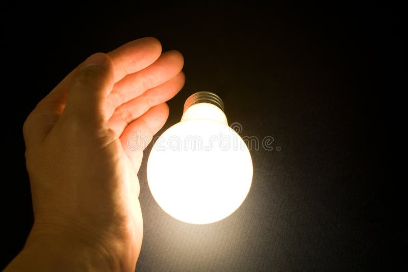 Hand and a Bright Light Bulb Stock Photo - Image of smart, lightbulb ...