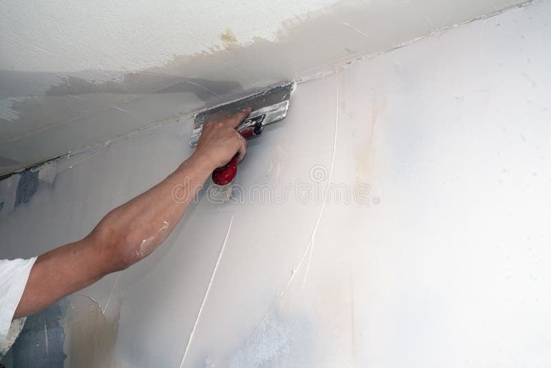 Builder with a Putty Knife, Apply the Putty To the Wall. Repair the ...
