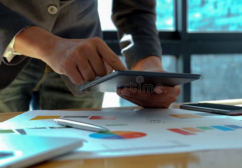 Hand Businessman Work on Tablet in Offices with Graphs on the Desk ...