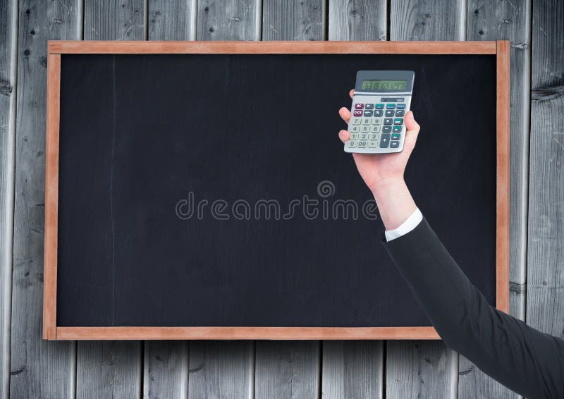 Hand with Calculator Against Chalkboard and Grey Wood Panel Stock Image ...