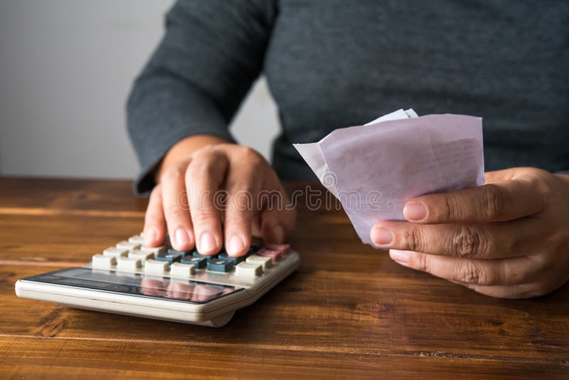 Hand on Calculator To Calculate Cost Based on Holding Bill. Stock Image ...