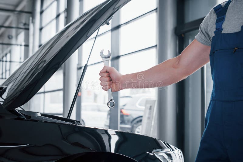 The Hand of a Car Mechanic with a Wrench in a Combi Zone Near the Car ...