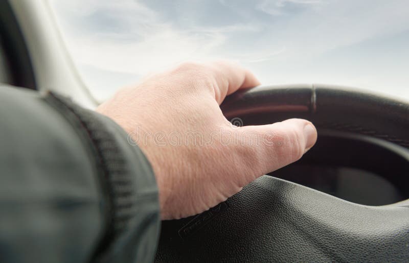 Hand on a Car Steering Wheel. Windshield and Perspective of the Sky ...