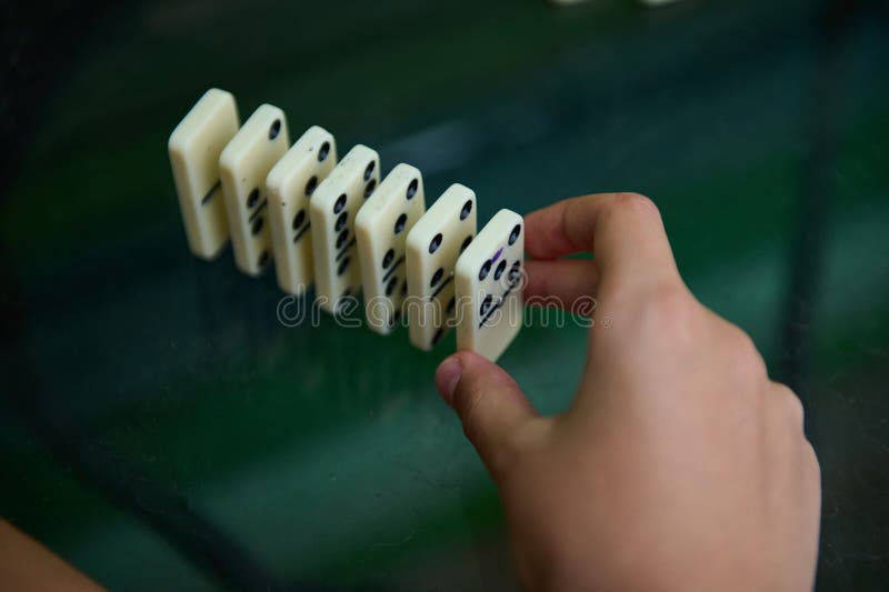 Hand Carefully Setting Domino Tile in a Sequential Line on a Table ...