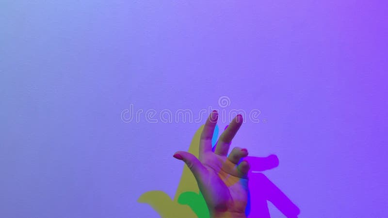 Hand Casting Colorful Shadows on a Wall with a Vibrant Light Effect ...