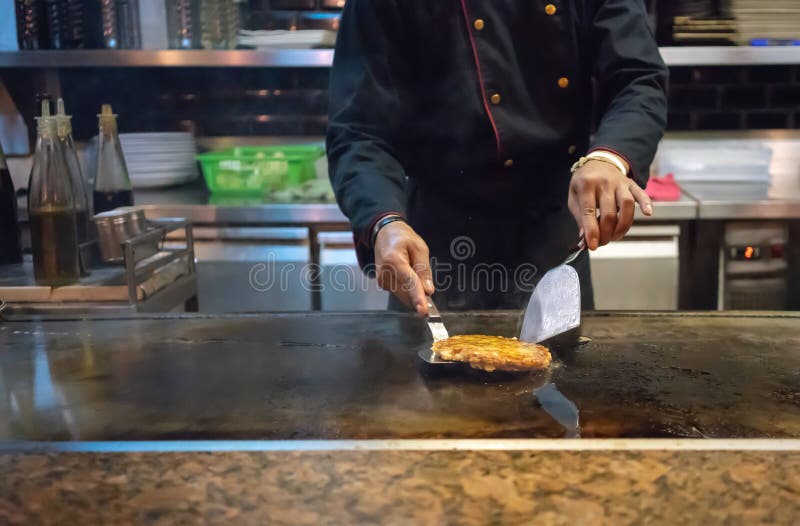 Hand of Chef Cooking Chicken Steak on Hot Pan in Front of Custom Stock ...